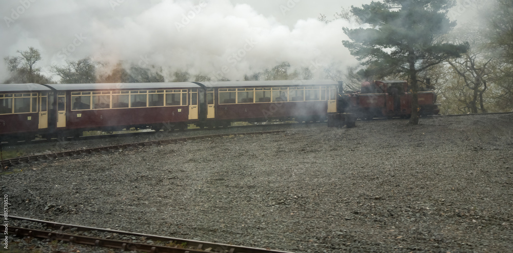 a vintage steam train and passenger carriages taking a bend in the ...