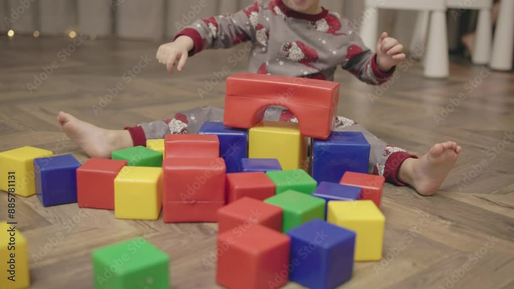 Little child boy eagerly playing with toy cubes blocks and bricks ...