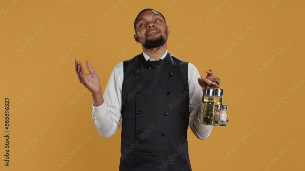 Catering staff with cruet set saying a prayer to God in studio, showing ...