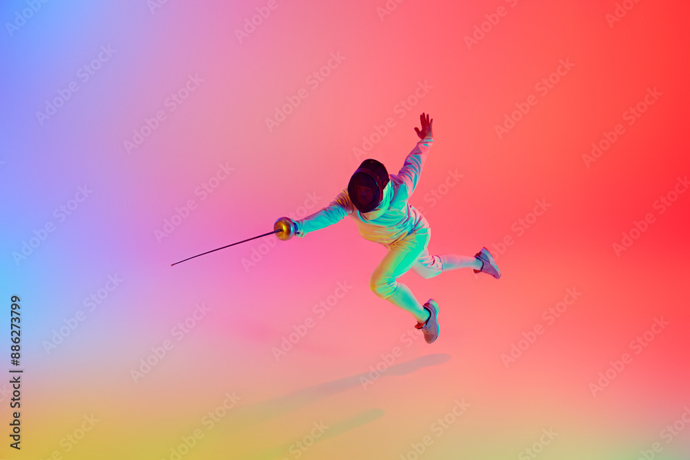 Young skilled fencer in full gear in attacking pose with one arm ...