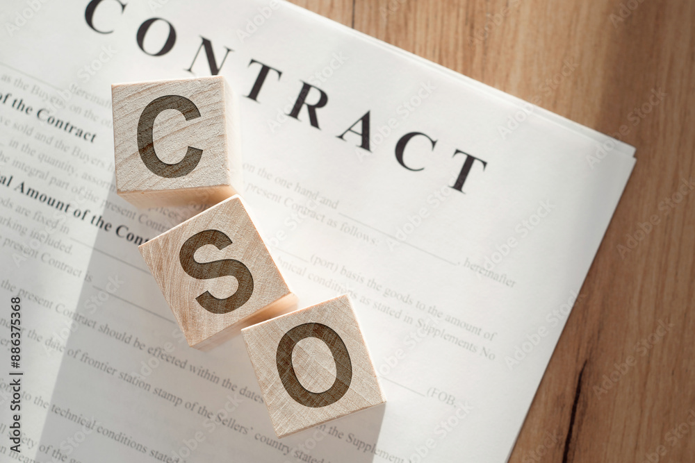 Wooden blocks spelling CSO on top of a paper labeled CONTRACT ...
