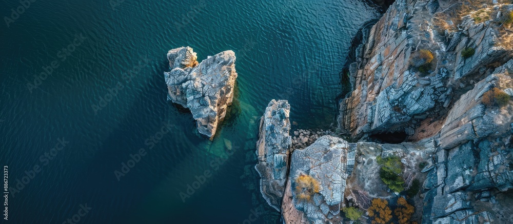An aerial view of a scenic lake nestled amidst rocky cliffs with a ...
