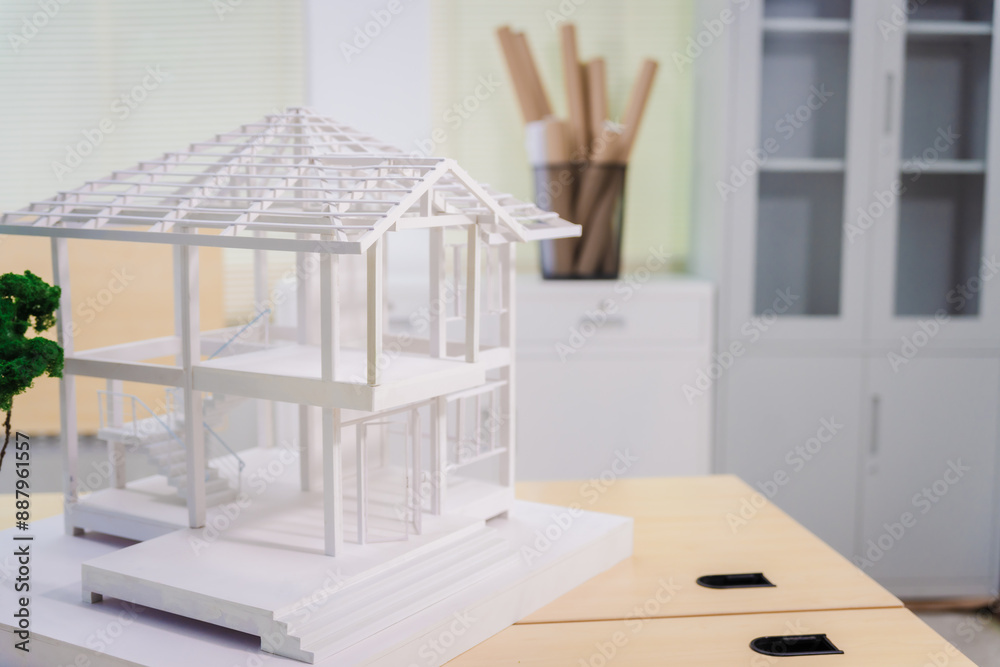 Desk of an engineer displays a concrete house structure under ...