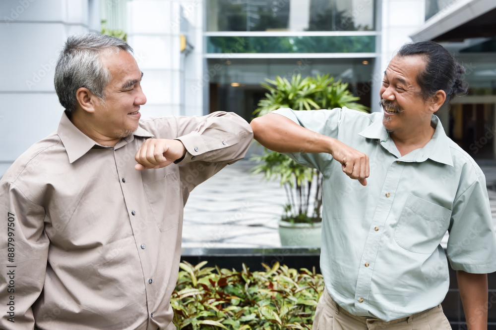 Old man greetings his old friend with elbow bump, alternative handshake ...