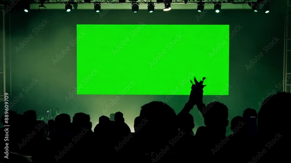 Pushing behind people clapping in silhouette in a movie theater as a ...