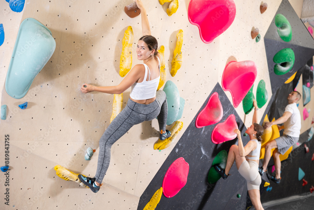 Cheerful young girl practicing bouldering in sports center, climbing ...