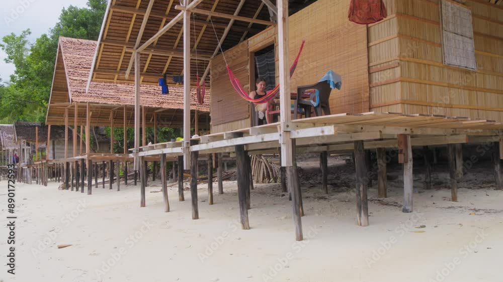 Woman Relaxing on a stilt hut veranda on Kri Island, Raja Ampat ...