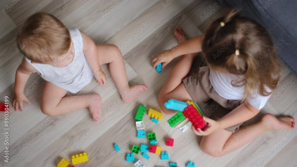 Top view of curious kids playing home with colorful cubes toys sitting ...