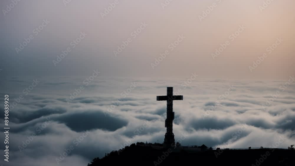towering Christian cross stands atop mountain, as clouds drift beneath ...