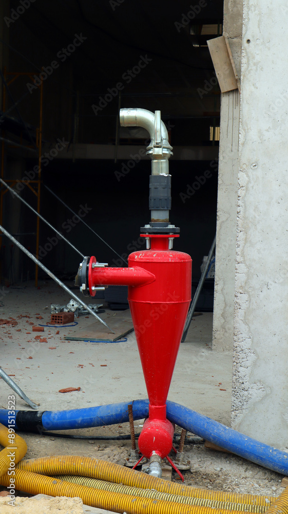 Red industrial cyclone separator is installed on the floor of a ...
