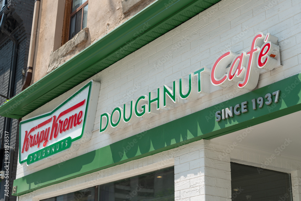 exterior building facade and sign of Krispy Kreme Café, a donut shop ...