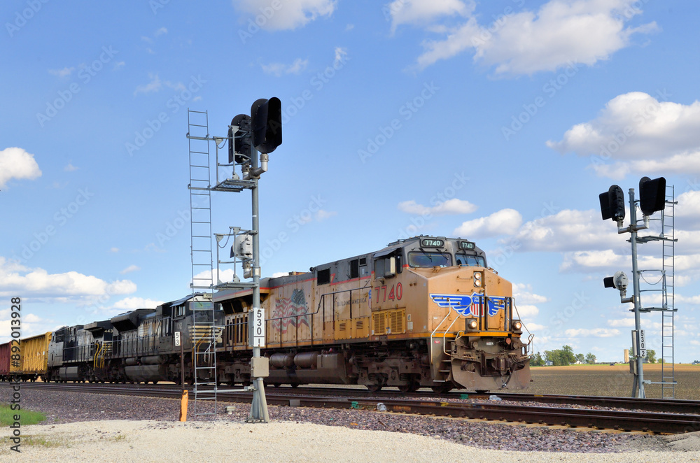Multiple locomotives, led by a Union Pacific unit power a westbound ...