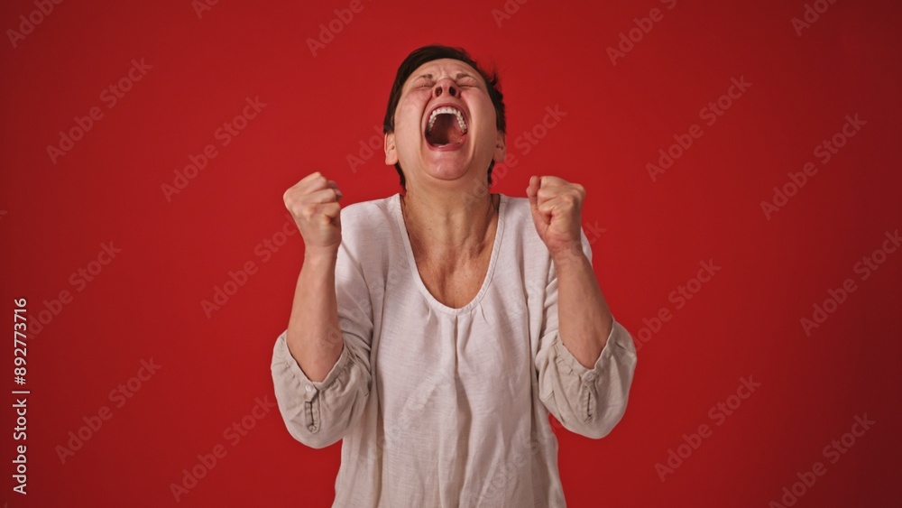 Desperate Outcry: Woman Over 50 on Red Background Screaming with Full ...
