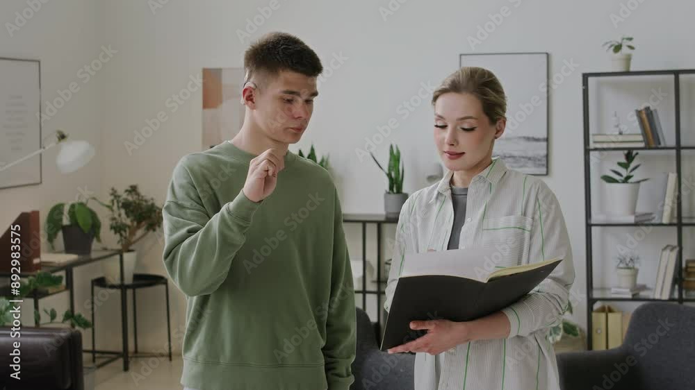 Medium shot of teenage deaf-mute Caucasian boy with reading ASL ...