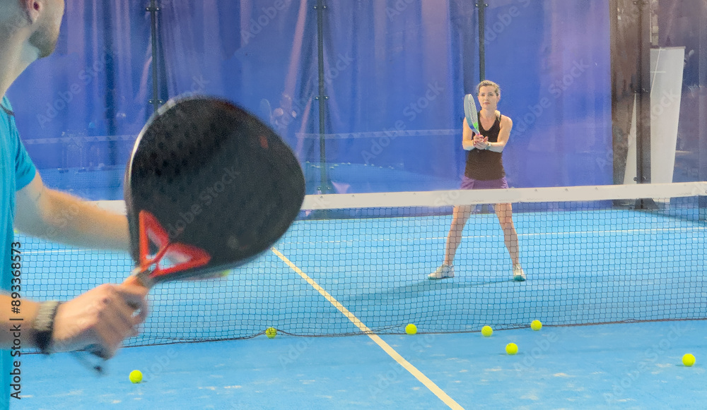 Empowering padel tennis training as a coach skillfully instructs a ...