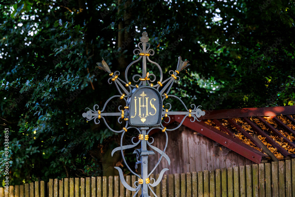 Wrought-iron cemetery cross with the Christian abbreviation of the name ...