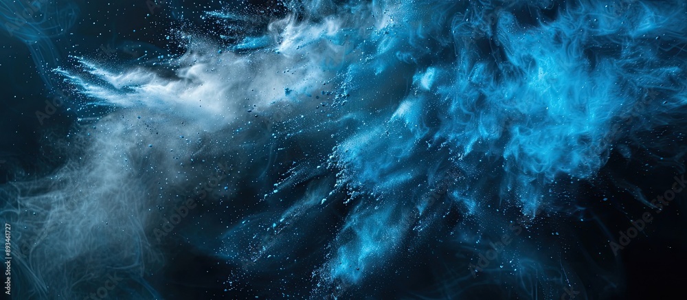 Freeze action of blue powder bursting on a dark background, forming an ...