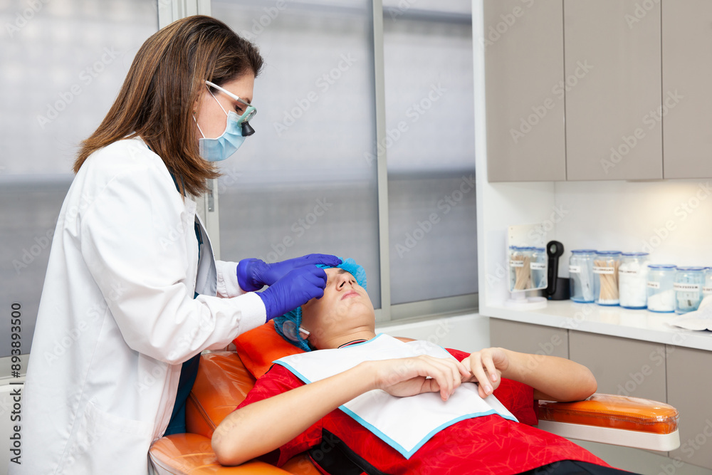 Skin lesion removal procedure. Dermatologist carrying out a removal of ...