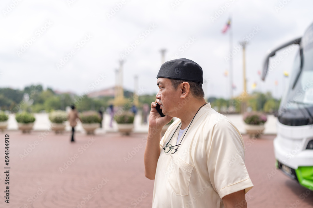 Fifty-something Muslim Malay person in religious attire, wearing a ...