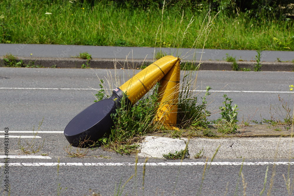 Asphalt street with traffic island with a broken pole with traffic sign ...