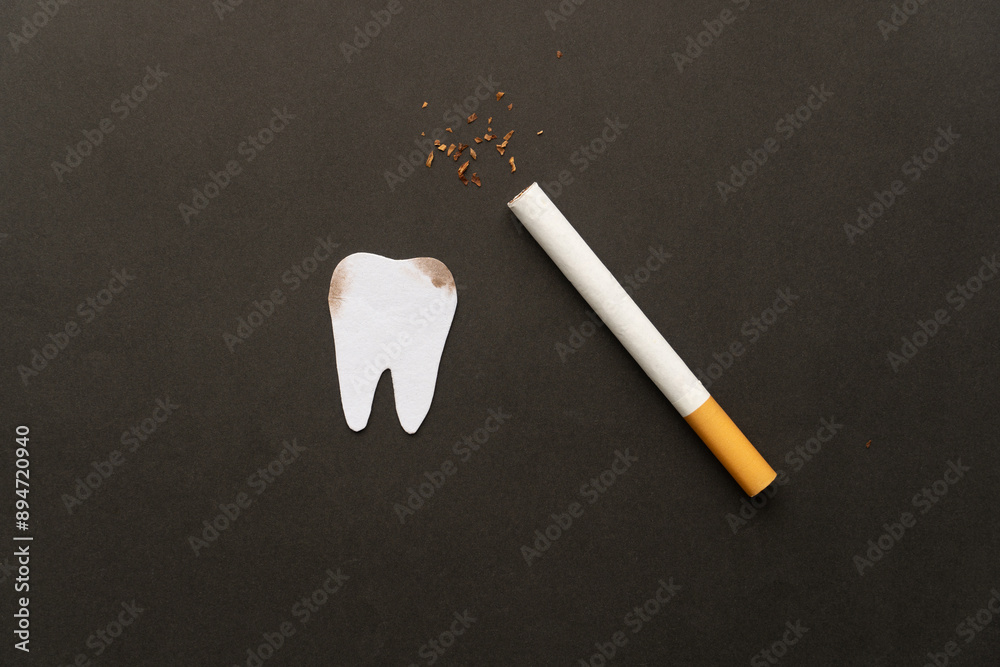 Cigarettes or tobacco with tooth shape on black background. Teeth ...