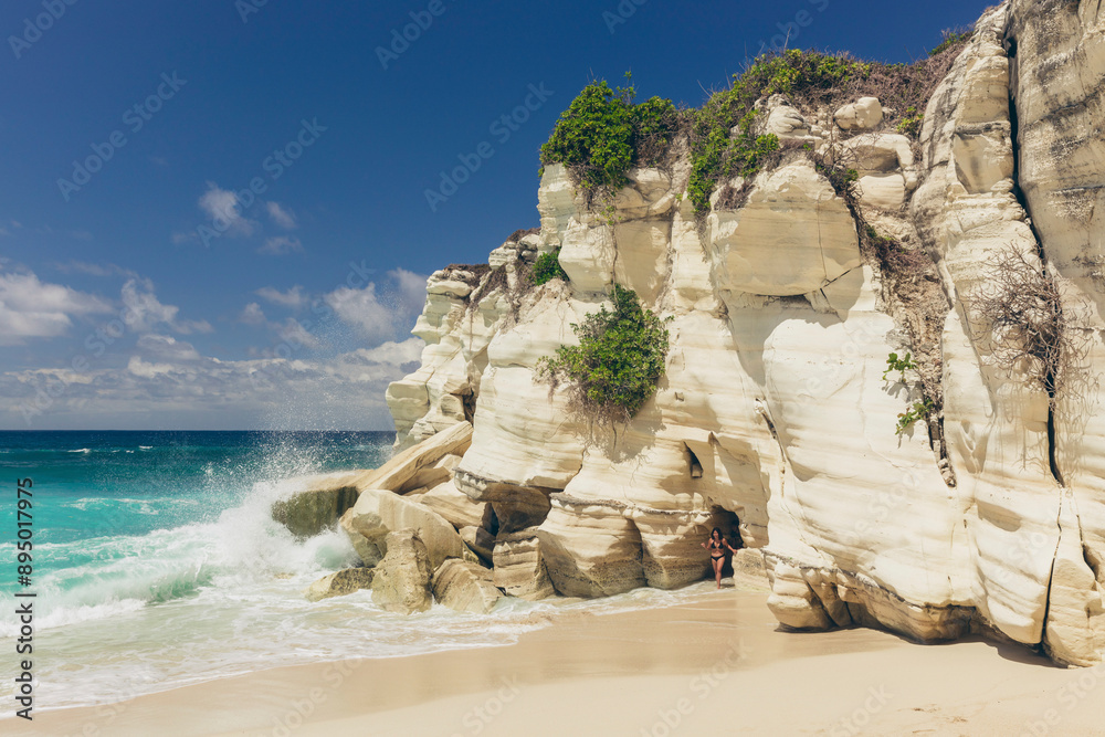 Pristine turquoise ocean water and white sand beach with rugged white ...