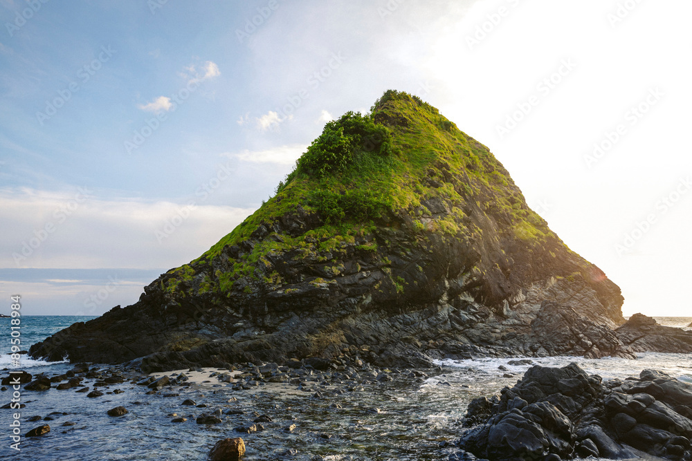 Peaked landforms and sunset light along a rugged Indonesian island at ...