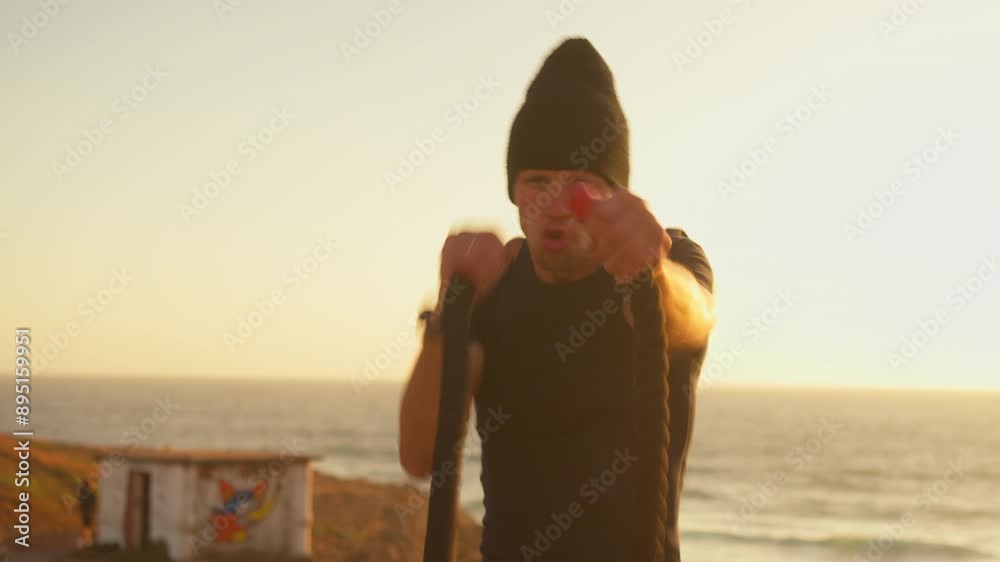 Athlete outline boxing into air on sea shore beach on sunset ...