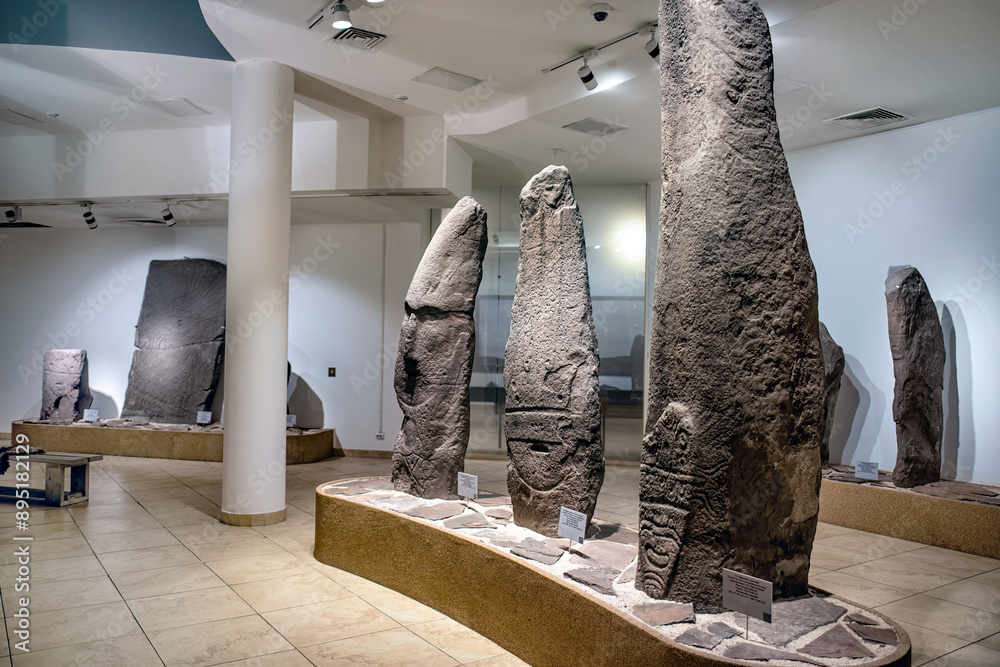 Ancient burial mounds with faces of various creatures and pictograms in ...