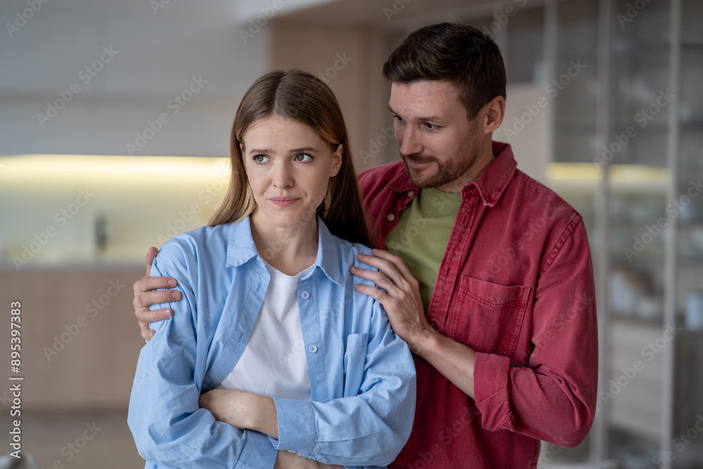 Upset and angry woman with PMS and husband calms and hugs her, provides ...