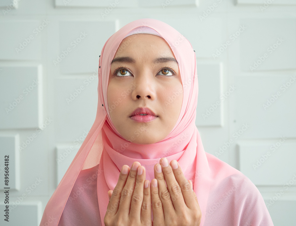 Asian beautiful Muslim woman in a pink hijab covering the head does a ...