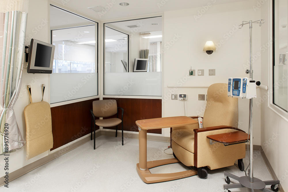 Interior view of a hospital treatment cubicle with a chair and a drip ...