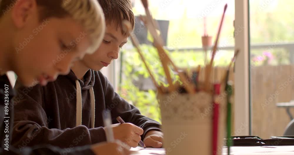 Two young boys fully engaged in artistic painting activities within a ...