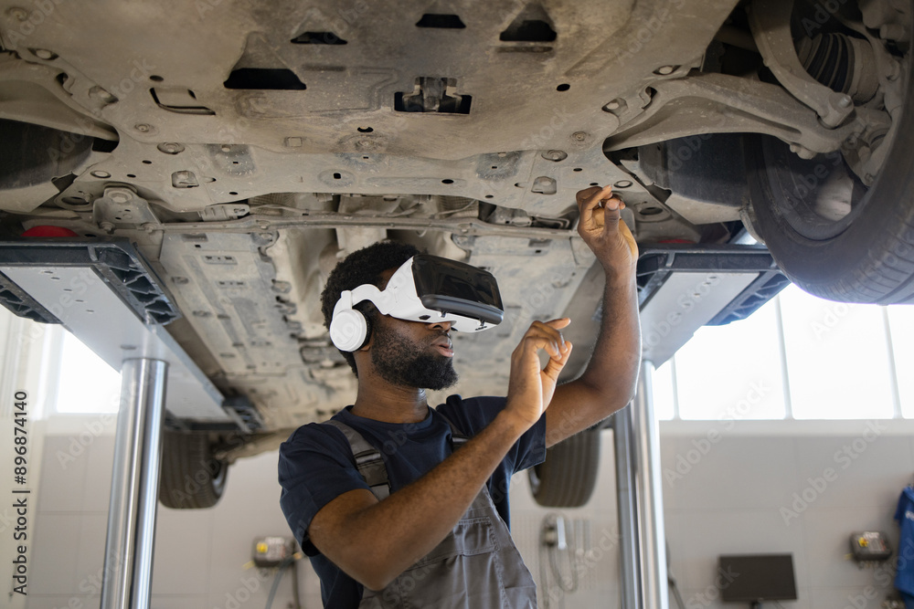 Mechanic wearing virtual reality headset performs 3D inspection of car ...