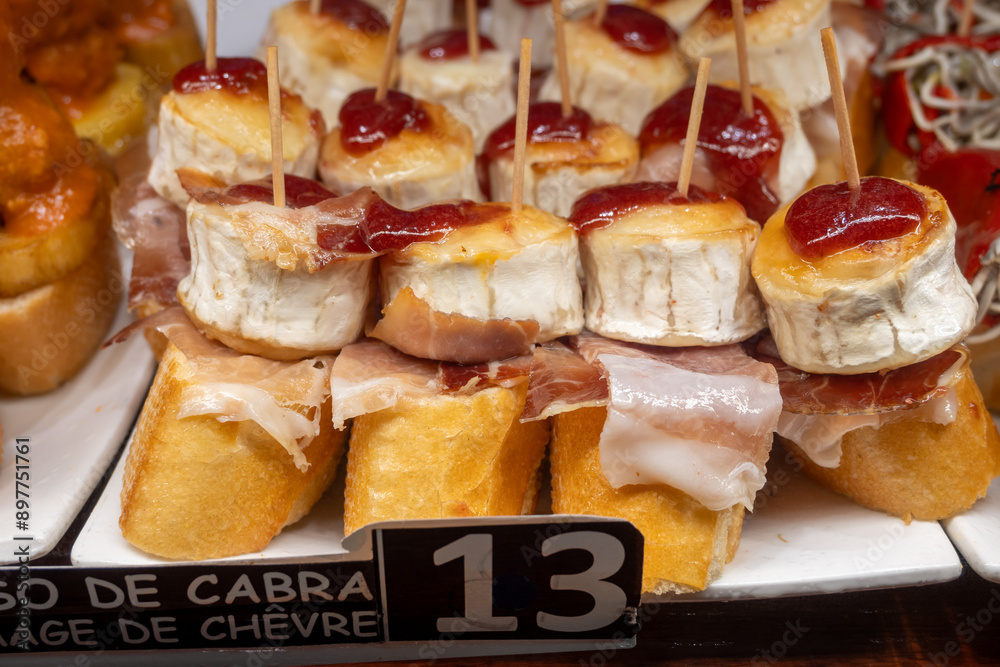 Typical snack of Basque Country, pinchos or pinxtos skewers with small ...