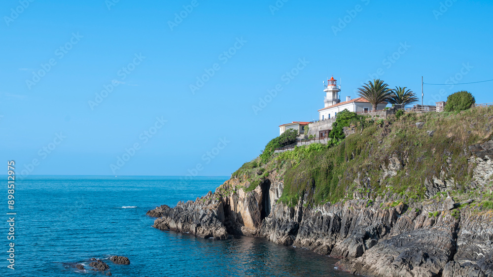Hermoso faro marítimo sobre una punta de roca adentrándose en el mar ...