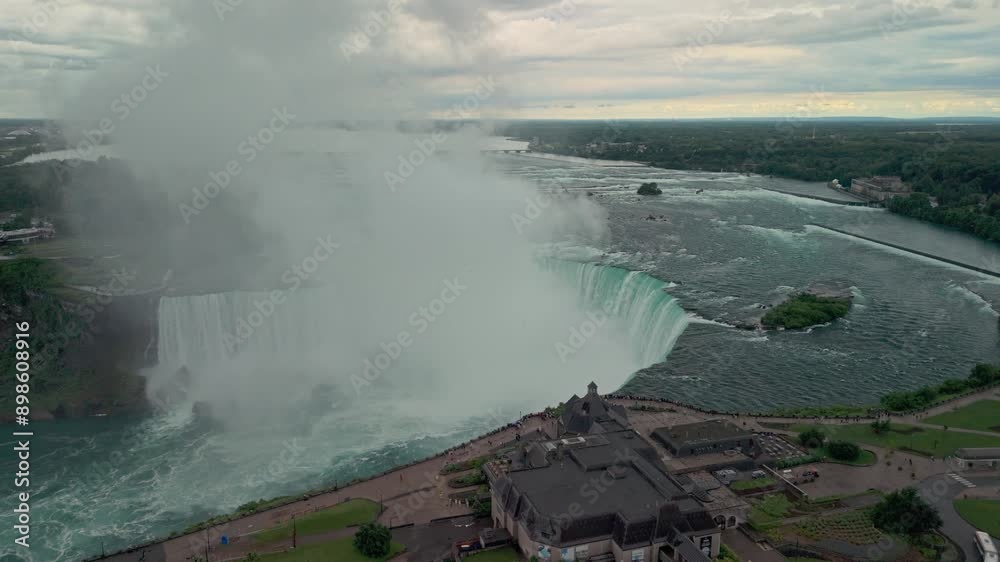 A cinematic drone view of Niagara Falls on a cloudy morning. The video ...