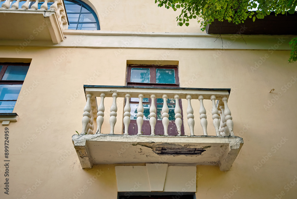 Damaged balcony with cracked concrete and falling plaster, building ...