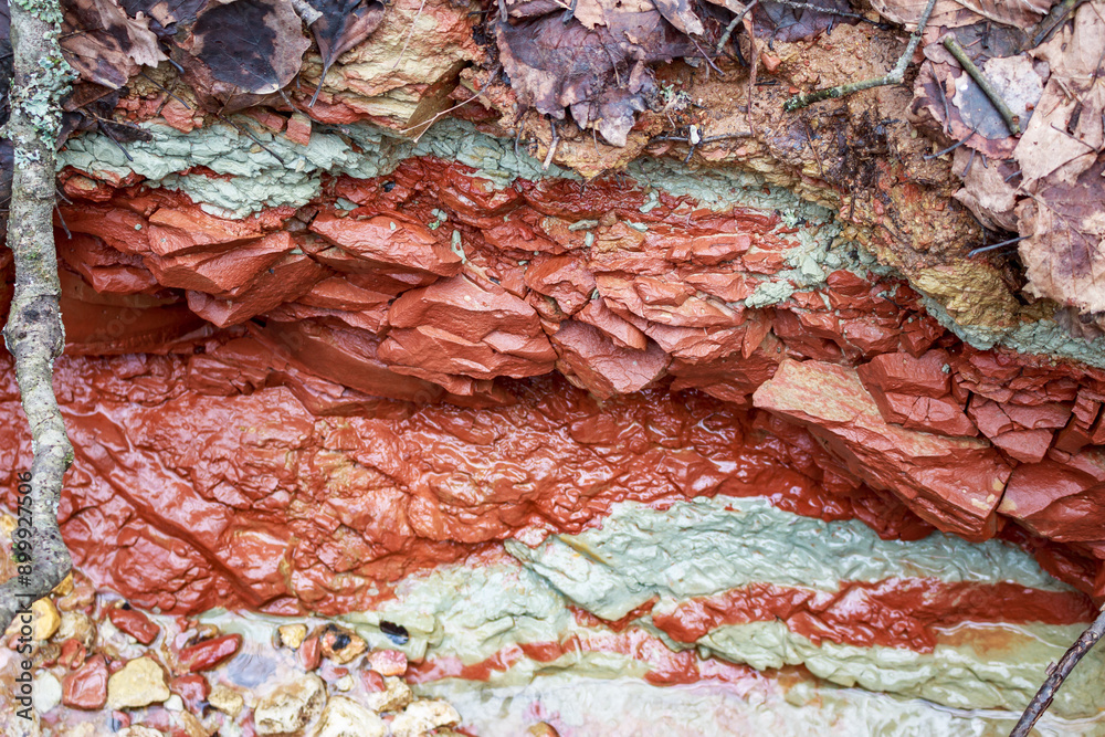 Texture of variegated red-blue clay exposed along the banks of a stream ...