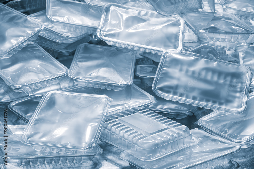A pile of plastic containers on a blue background ready for packaging ...