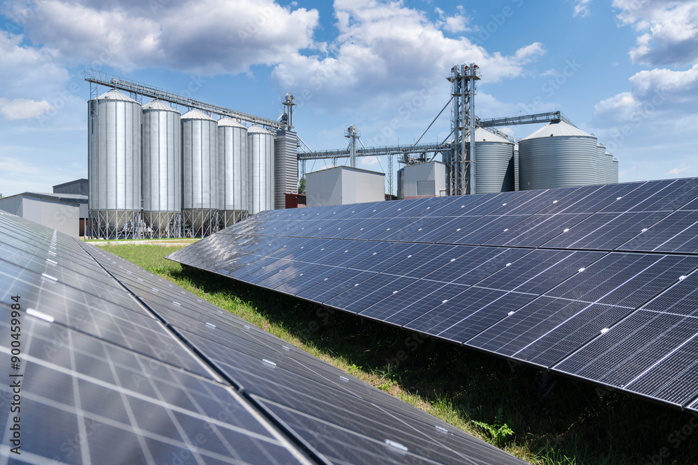 Modern farm using renewable energy. Solar panels with silos in the ...