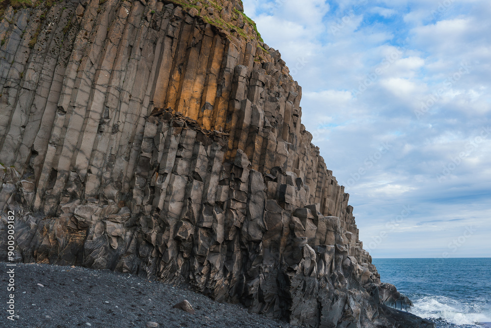 Dramatic basalt columns rise from the black sand of Reynisfjara Beach ...