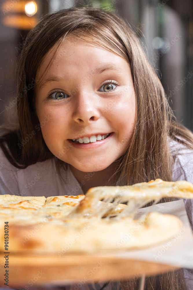 Cute girl and four cheese pizza close-up. A pre-teen girl looks into ...