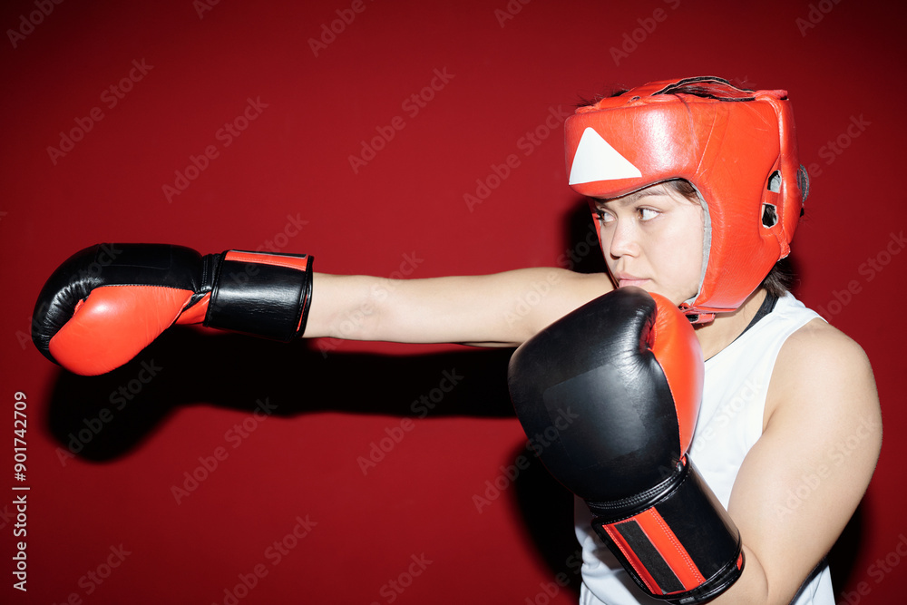 Young strong woman in red leather boxing gloves and protective helmet ...