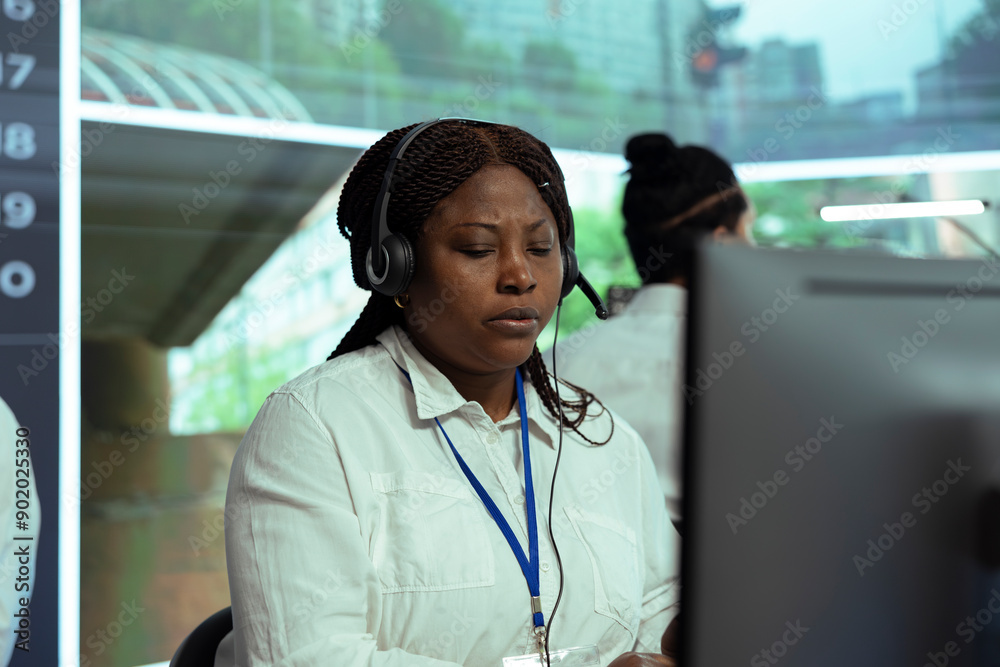 African american woman looks at real time surveillance footage and ...