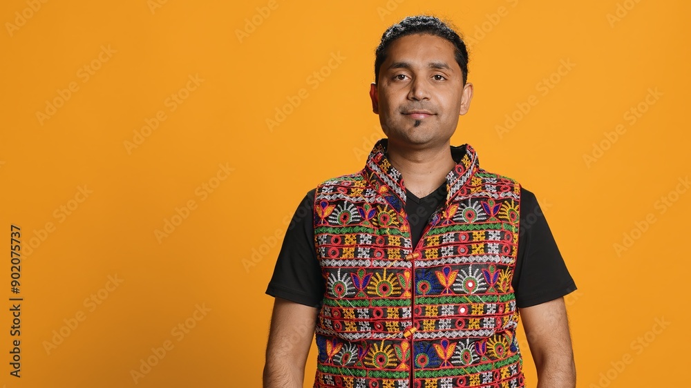 Portrait of jolly indian man with colorful garment smiling, looking ...