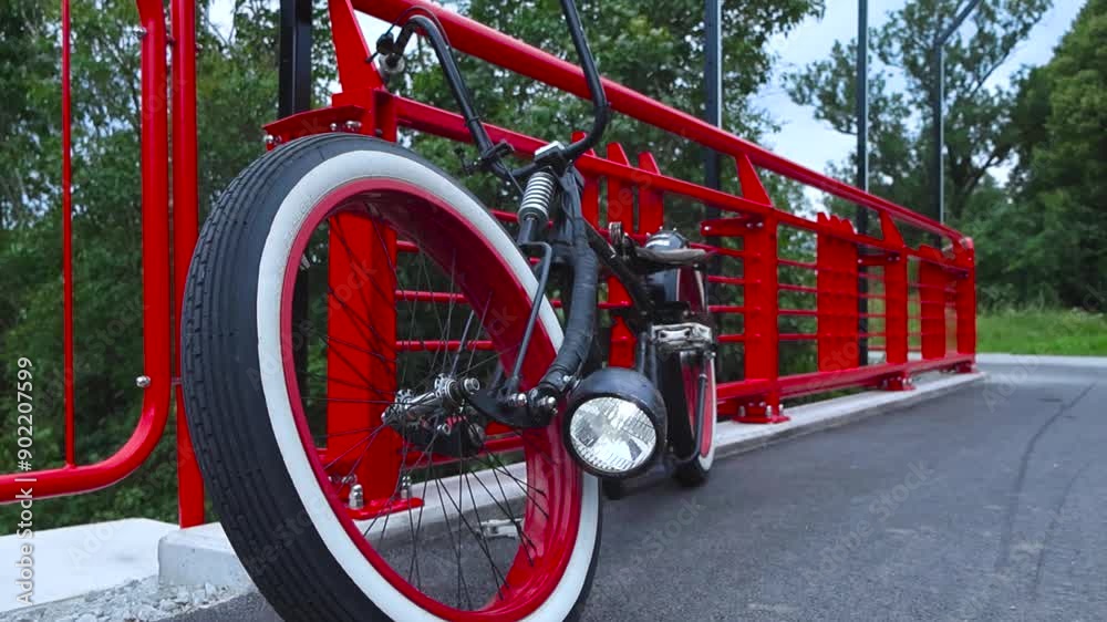 Footage shows a big black chopper styled bike or a bicycle on a bridge ...