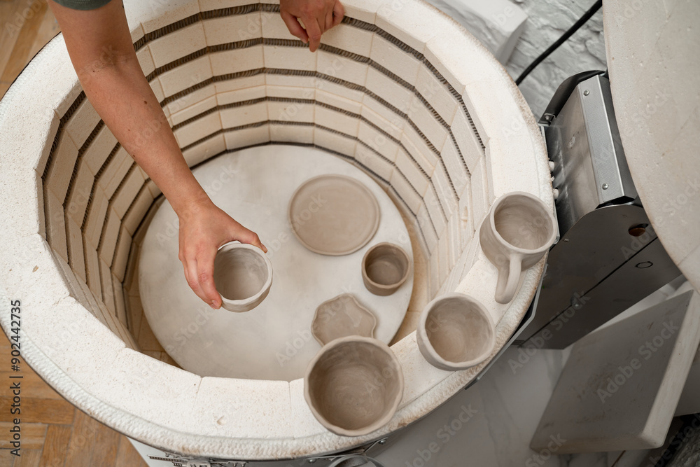 Placing pottery in a muffle furnace to heat it to high temperatures ...