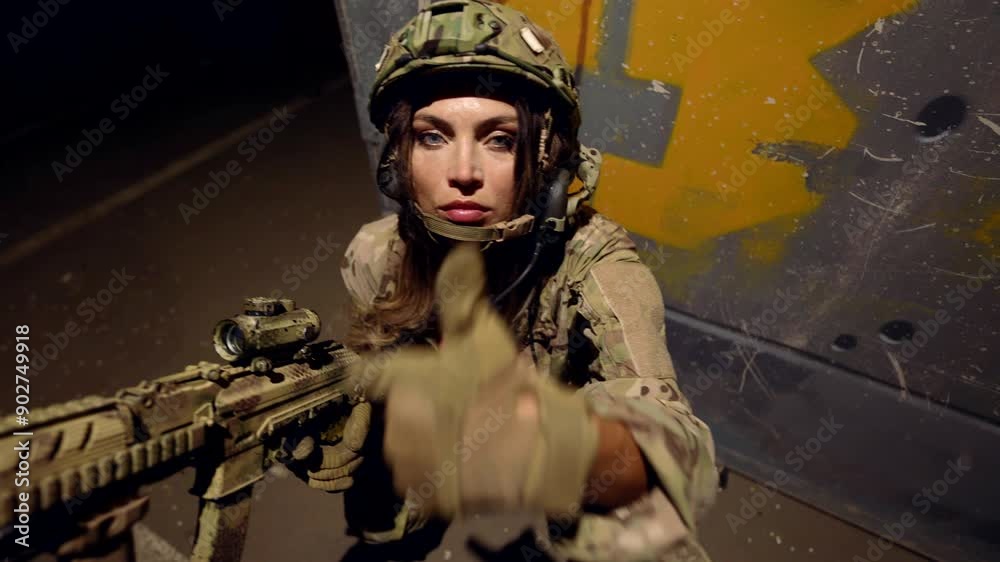 A pretty woman in a camouflage suit and helmet with a microphone, with ...