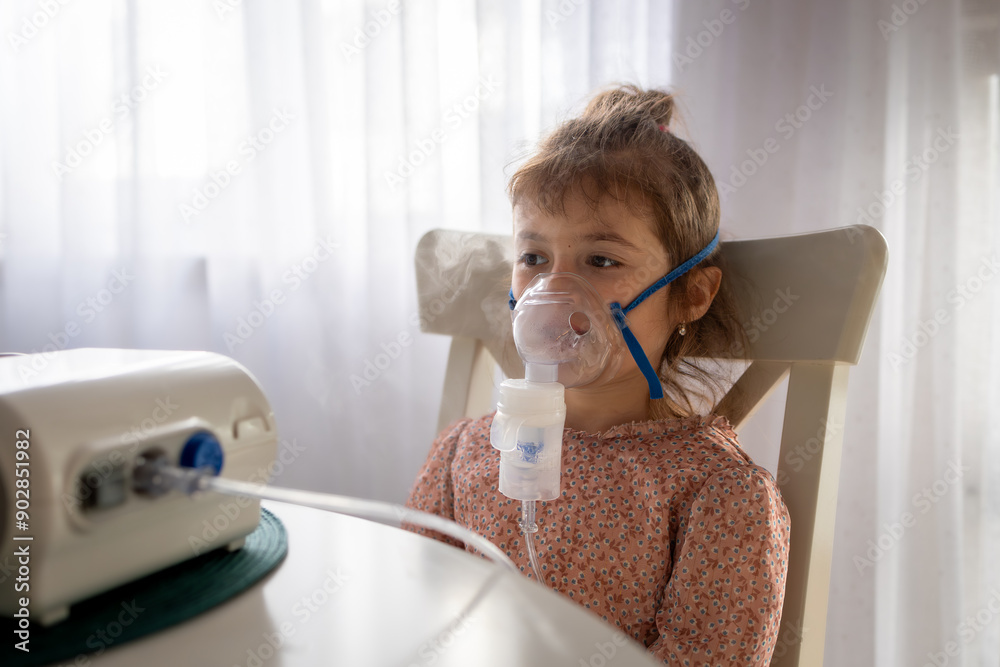 Cute little girl in the mask of an inhaler. Procedure of inhalation at ...